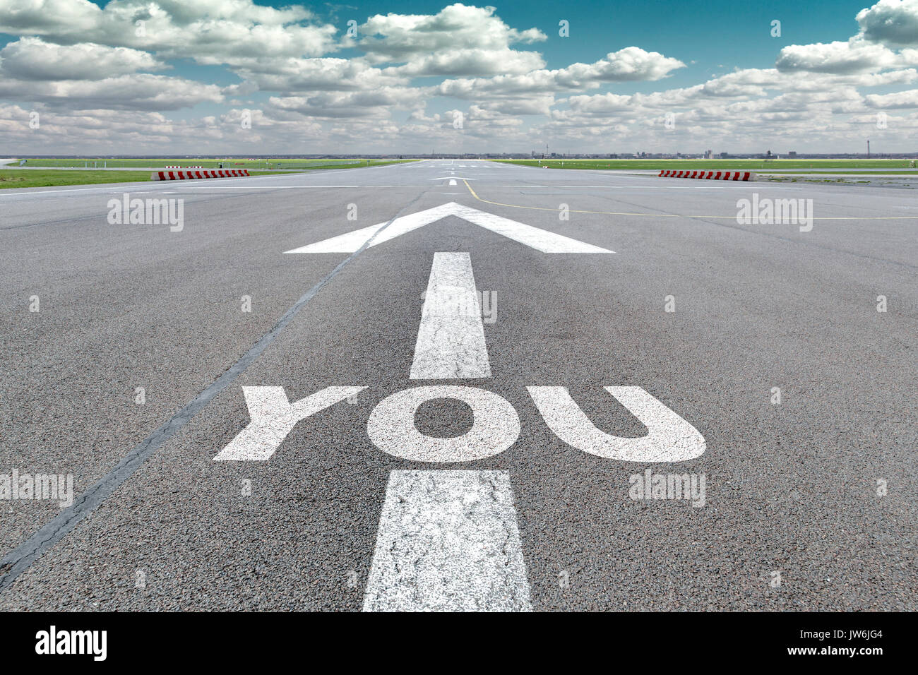 Runway of airport with arrow guideline and you letters painted on the ...
