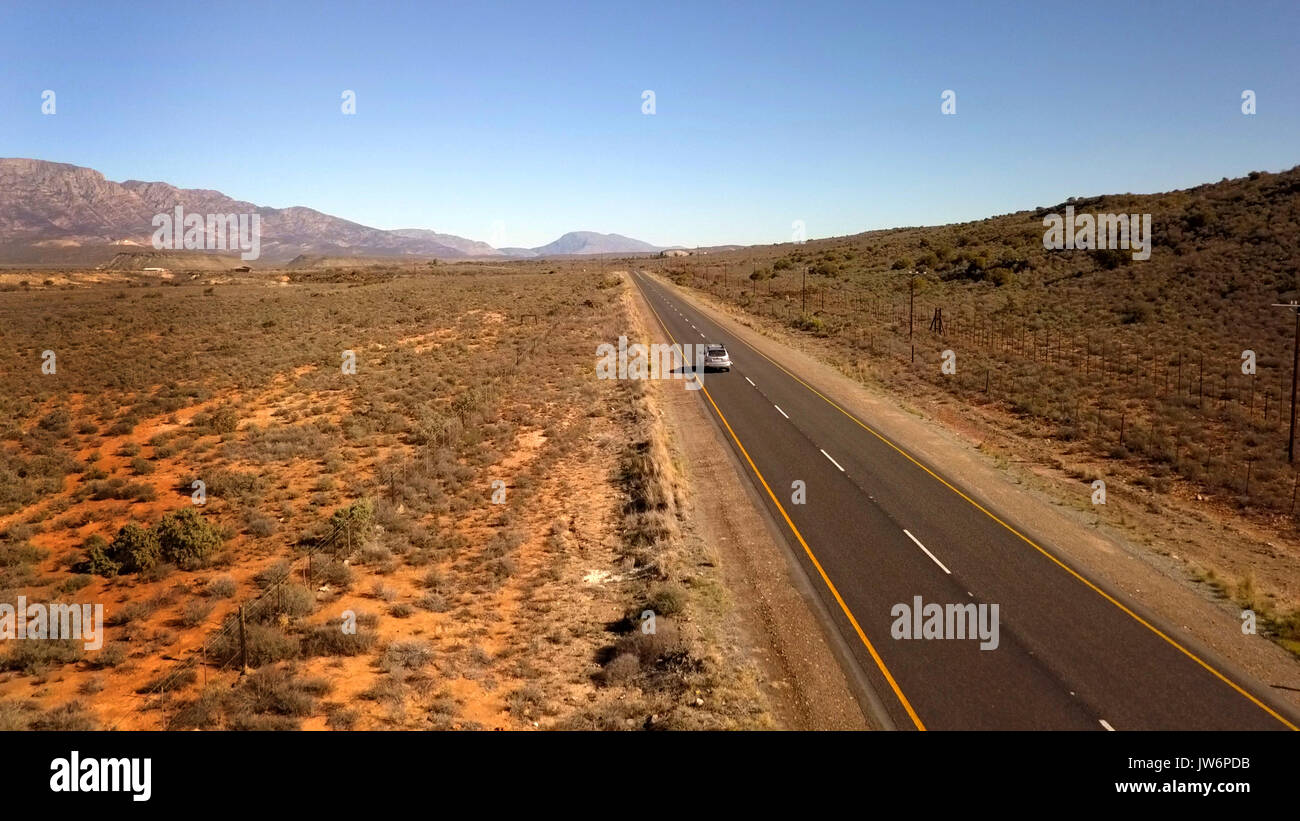 Car driving down long open road Stock Photo - Alamy