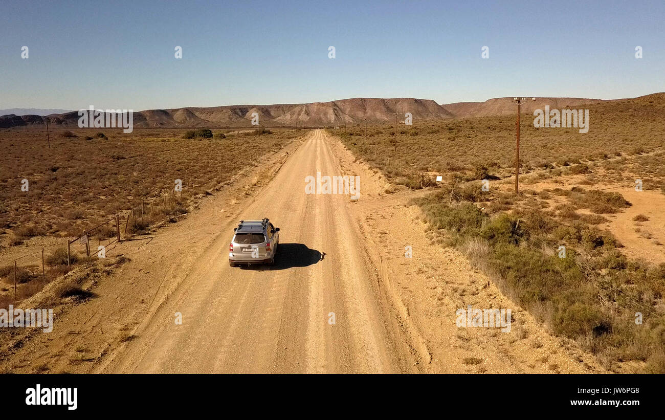 Car driving down long open road Stock Photo - Alamy