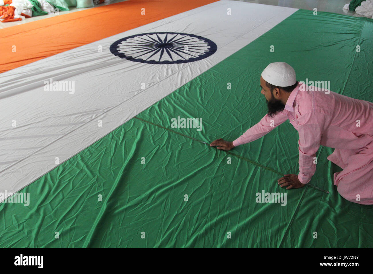 MUMBAI, INDIA – AUGUST 10: A worker in a flag factory giving final ...