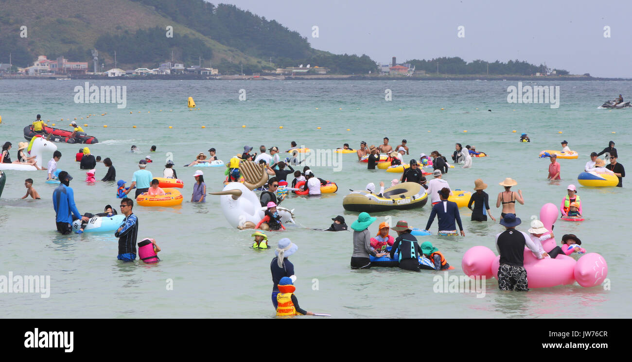 Jeju beach Visitors enjoy swimming at a beach on the southern resort ...