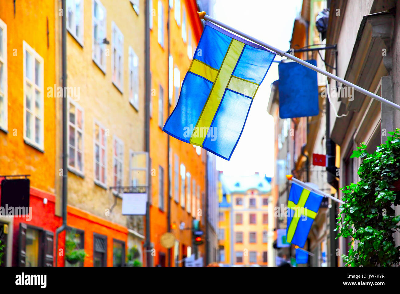 Old street in Stockholm with swedish flags, Sweden. Shallow DOF, focus ...