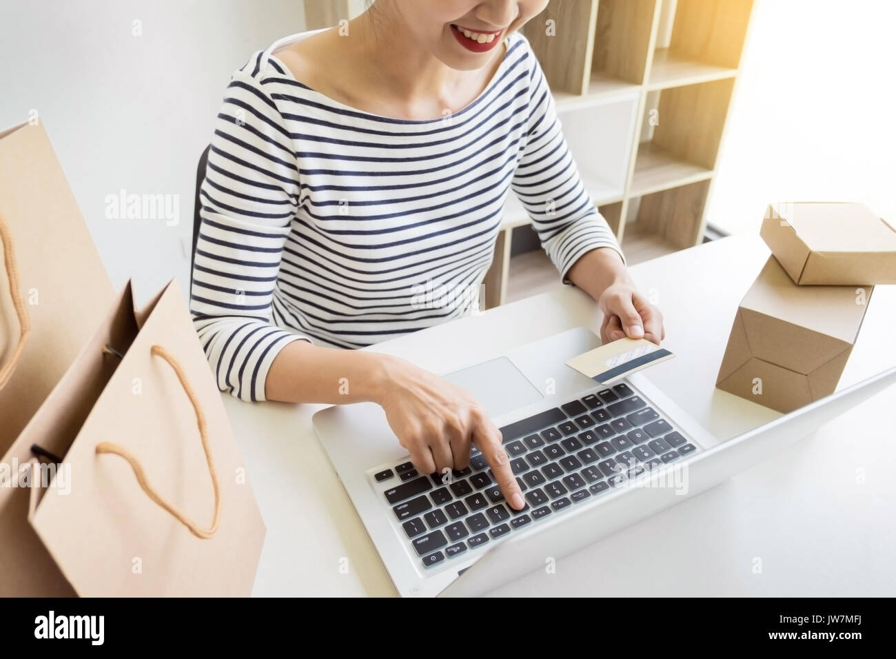 Closeup of happy young woman holding credit card inputting card ...