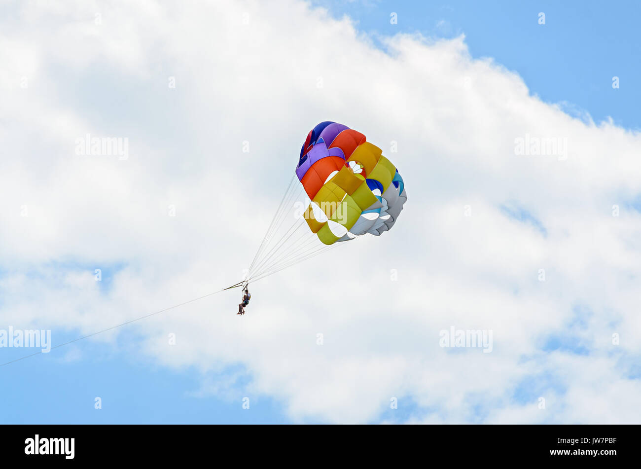Colored parasail wing in the blue clouds sky, Parasailing also known as ...