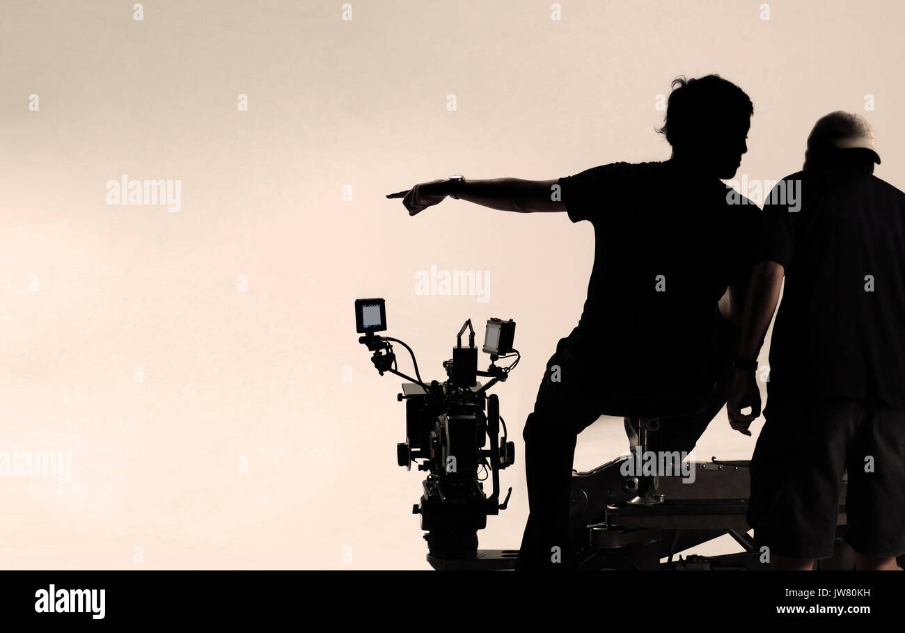 Silhouette behind the scenes of camera man and production team talking ...