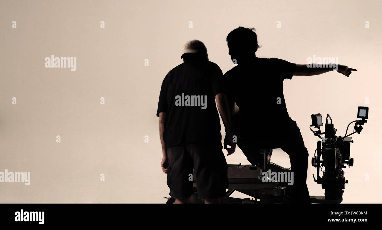 Silhouette behind the scenes of camera man and production team talking ...