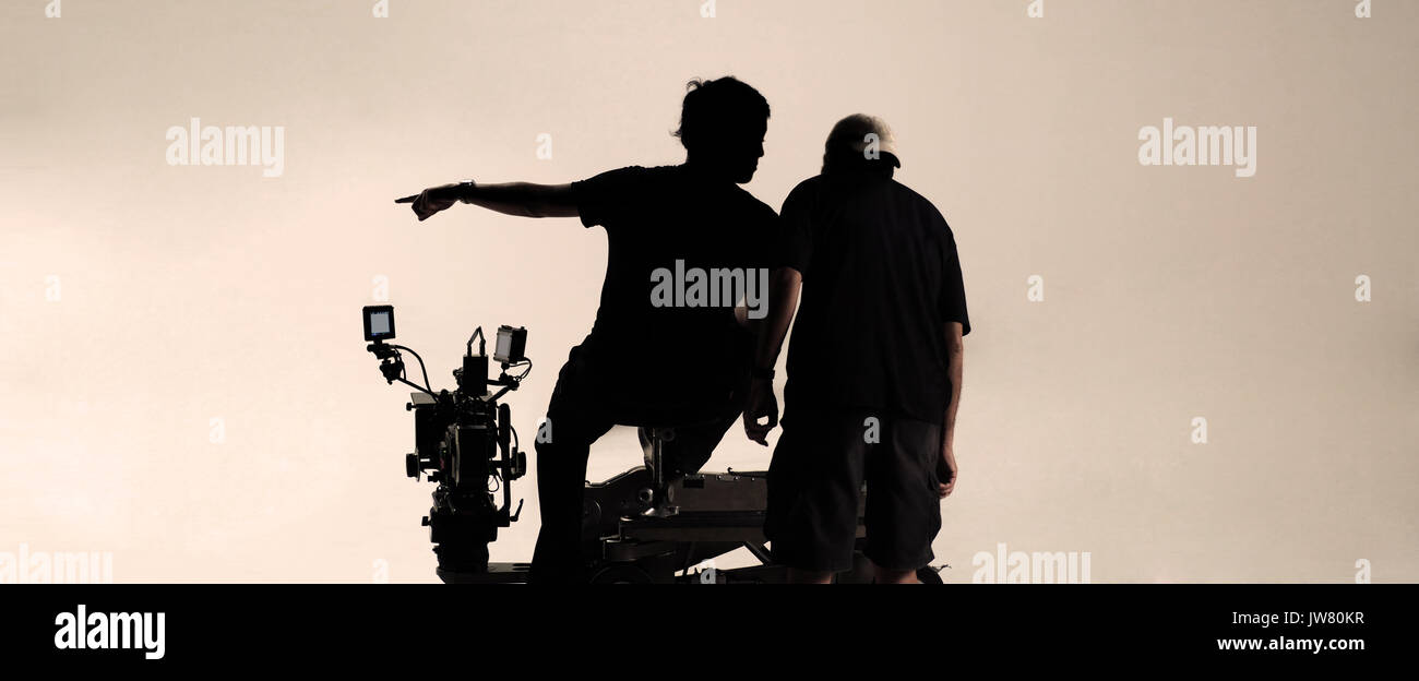 Silhouette behind the scenes of camera man and production team talking ...