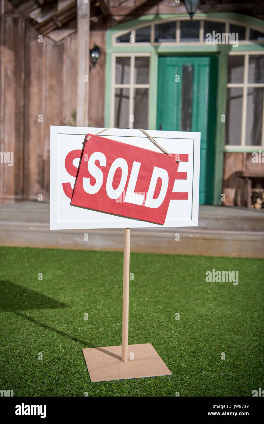 sale banner with sold card standing near new house Stock Photo - Alamy