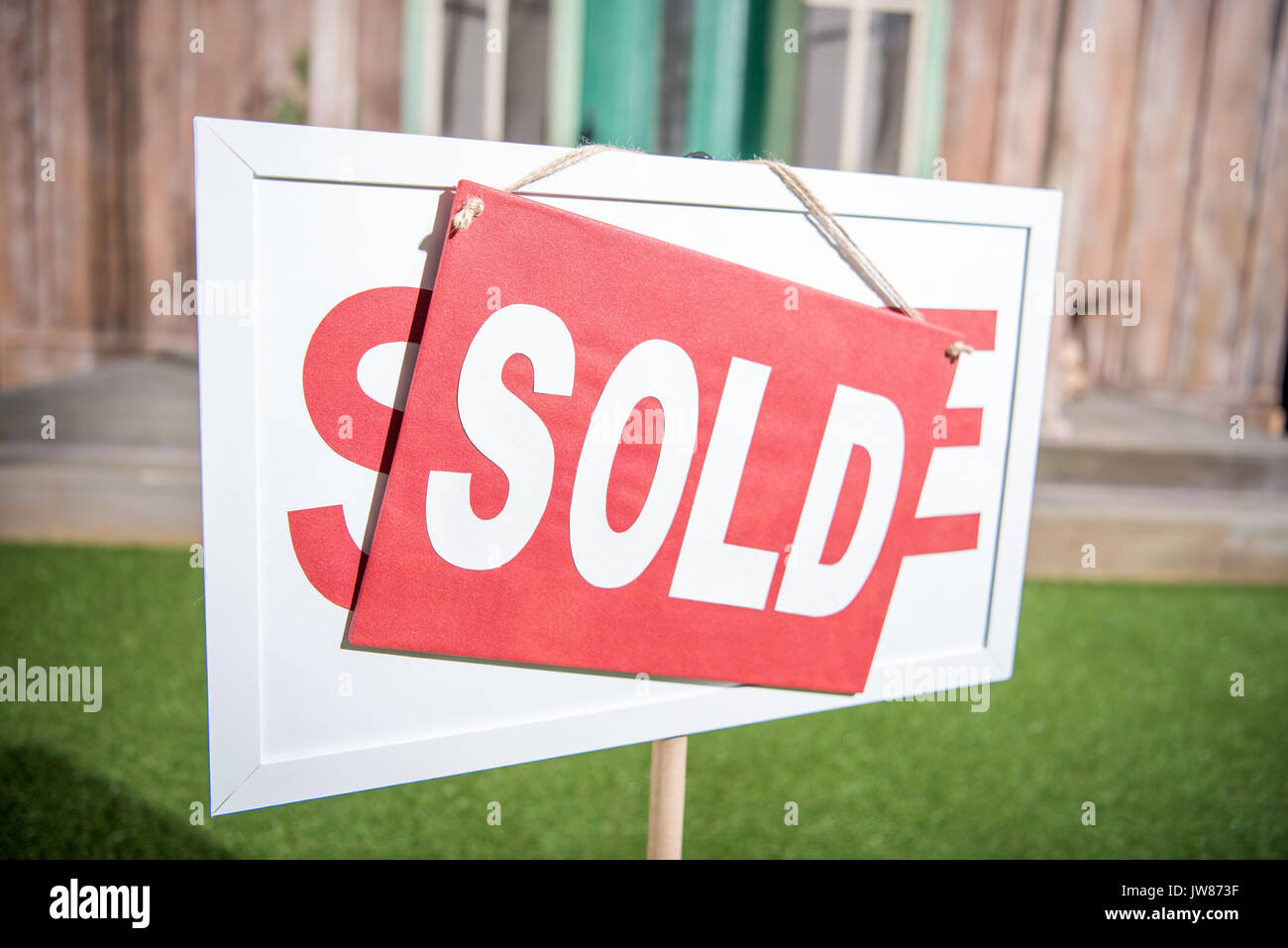 sale banner with sold card standing near new house Stock Photo - Alamy