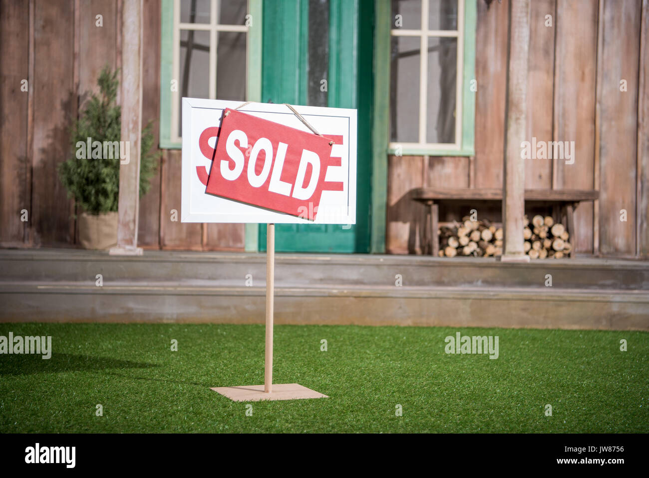 sale banner with sold card standing near new house Stock Photo - Alamy
