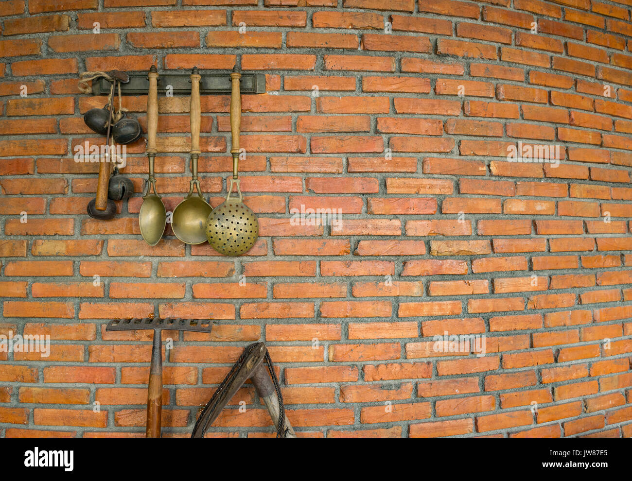 Brick wall with a spade and ladle hanging Stock Photo - Alamy