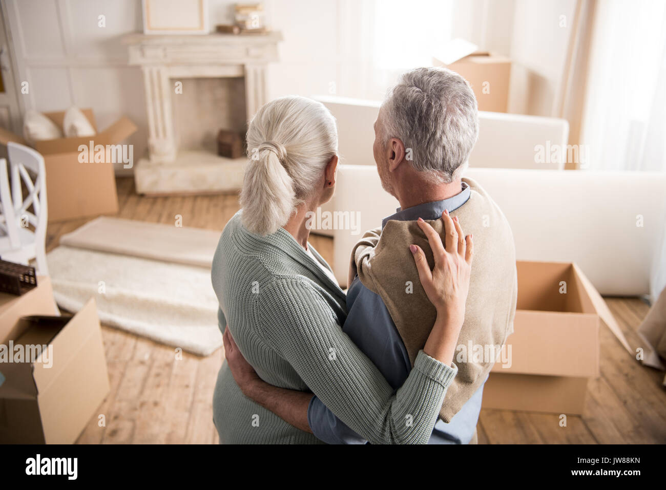 back view of senior couple hugging each other at new home Stock Photo ...