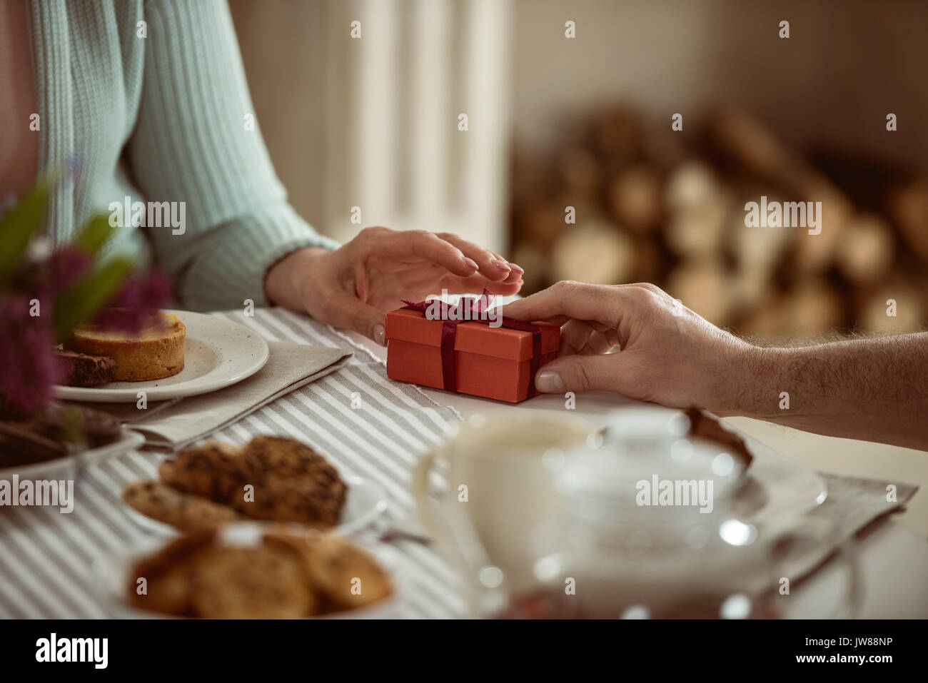 cropped view of senior husband presenting gift box to his wife Stock ...