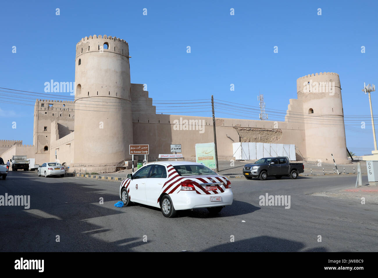 A taxi drives past As Suwayq Castle in the town of As Suwayq on the ...