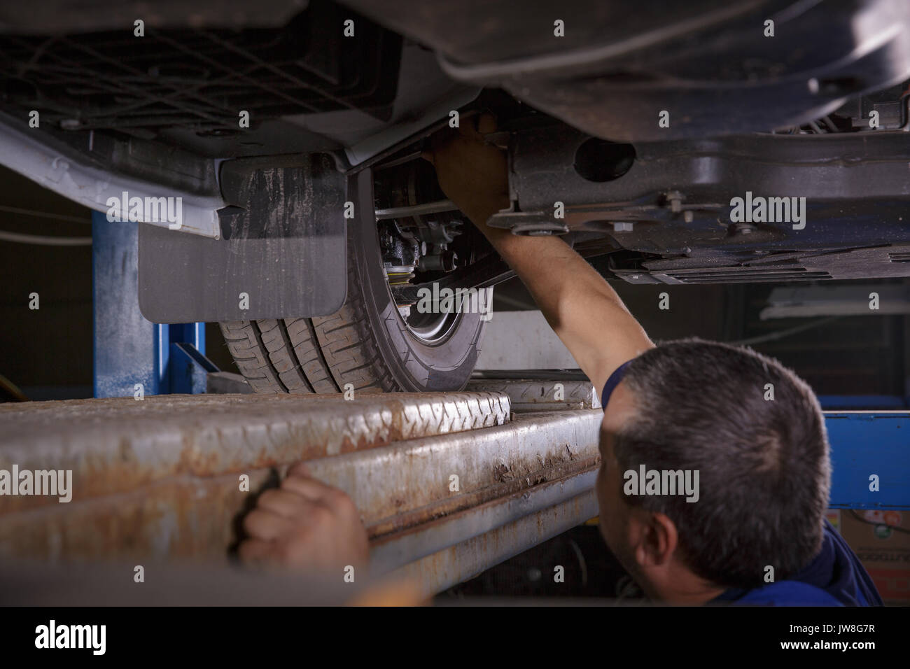 Mechanic Works on a Car in body shop Stock Photo - Alamy