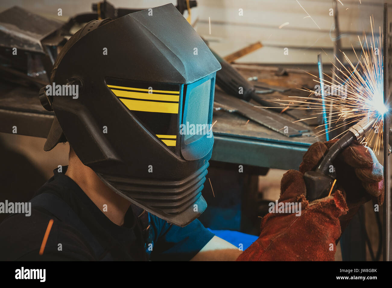 Male in face mask welds with argon-arc welding Stock Photo - Alamy