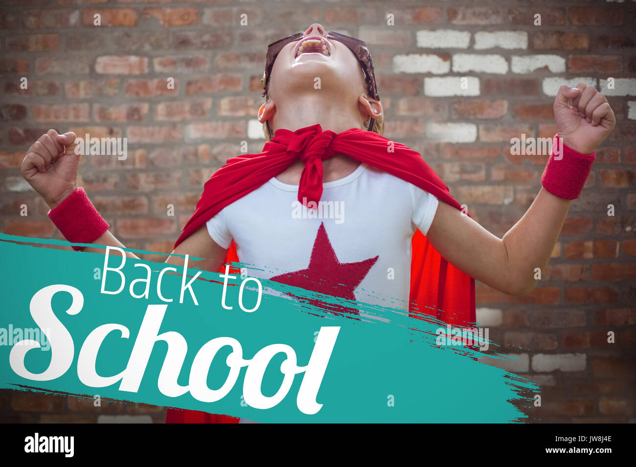 Boy screaming with arms raised against brick wall Stock Photo - Alamy