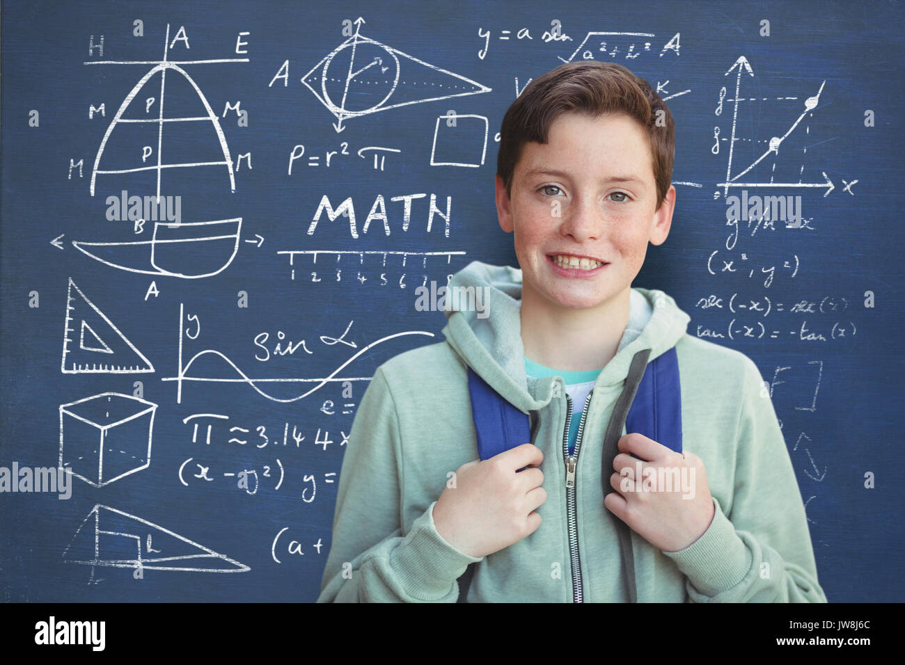 Portrait of smiling innocent boy against mathematics text with ...
