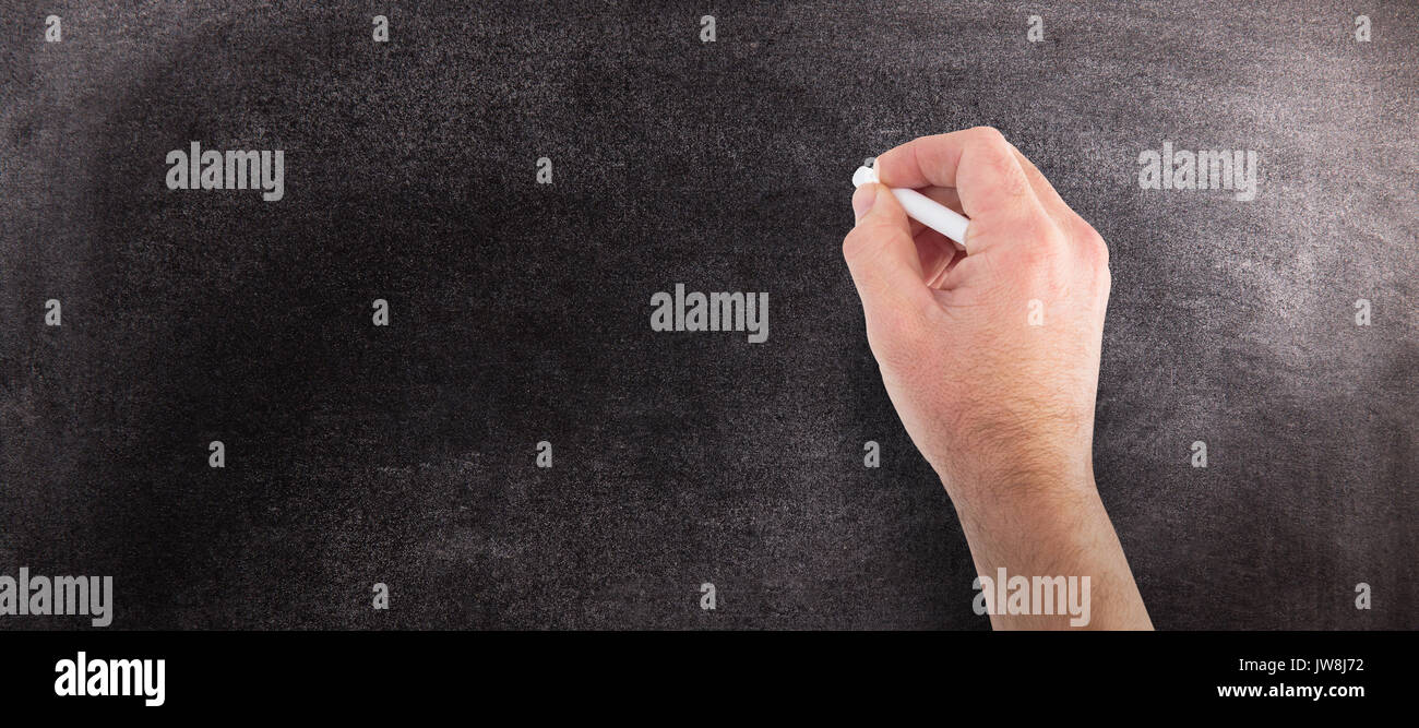 Hand writing with chalk against black background Stock Photo - Alamy