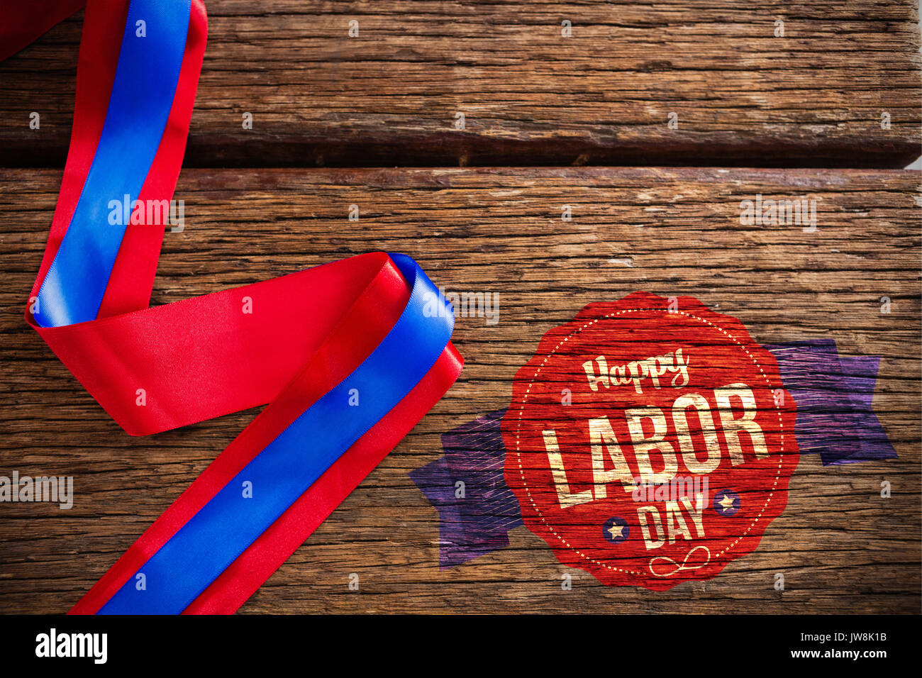 Happy labor day text in banner against red and blue ribbon on table ...