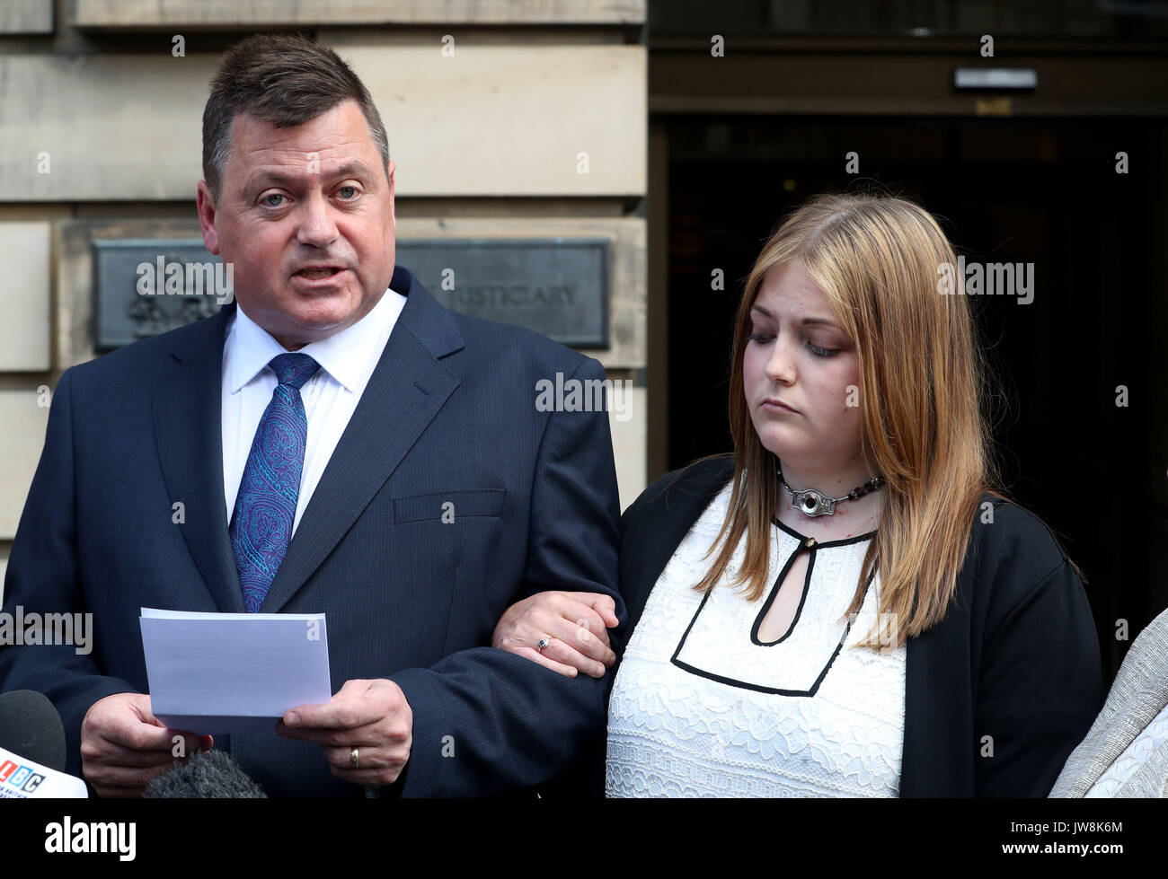 Rebecca Williams looks on as her father Phillip reads a statement on ...