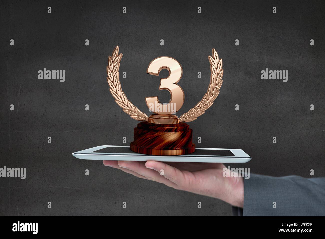 Digital composite of Person holding a tablet with a trophy Stock Photo ...