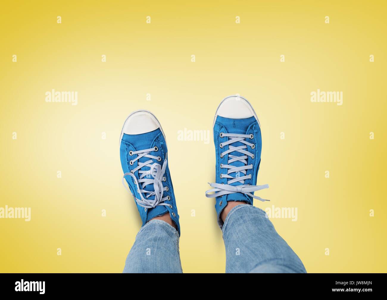 Digital composite of Blue shoes on feet with yellow background Stock ...