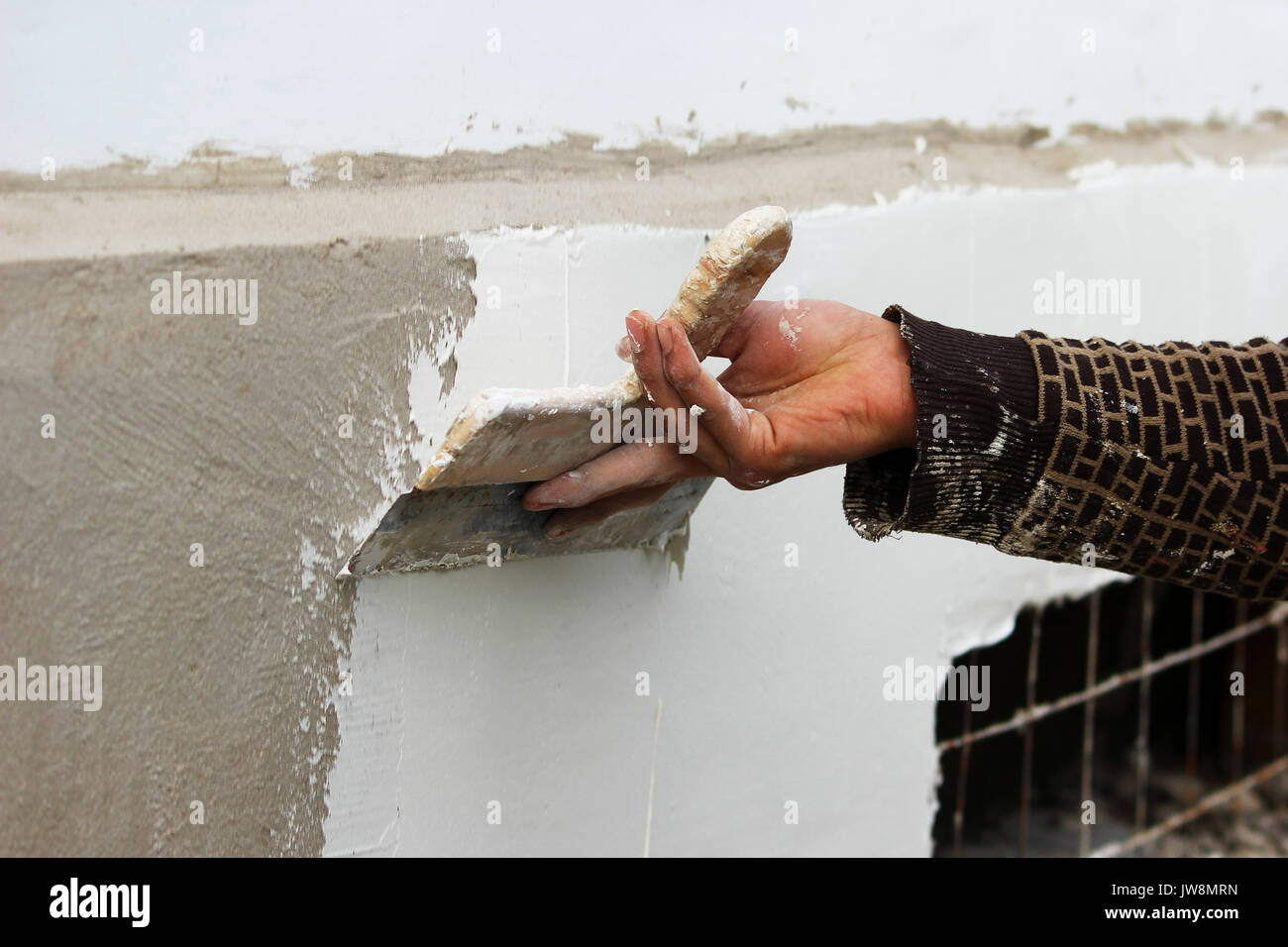 Construction worker plasterer with wall plastering tools renovating ...