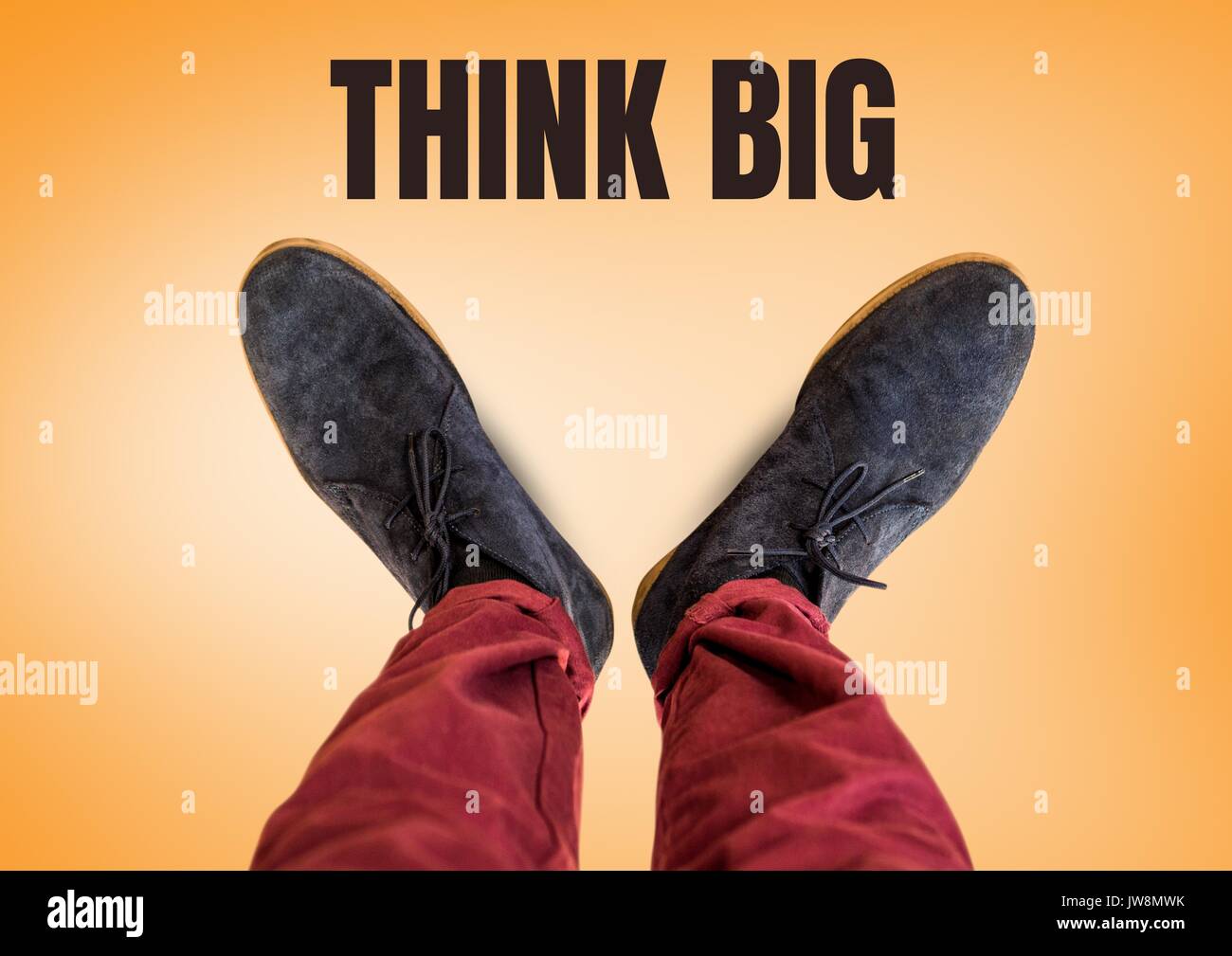 Digital composite of Think big text and Grey shoes on feet with orange ...