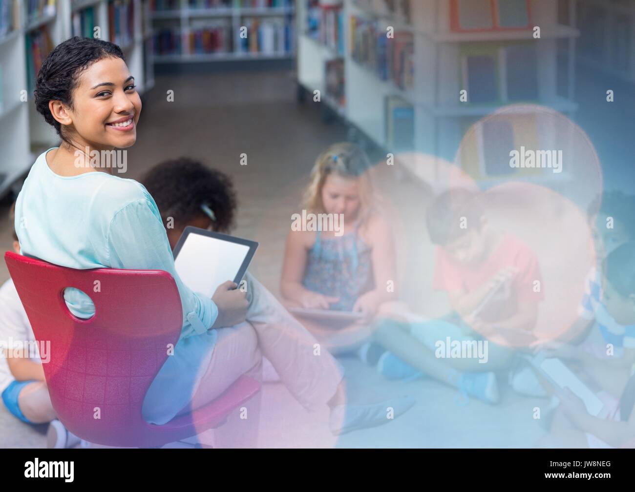 Digital composite of Elementary school teacher with class in library ...