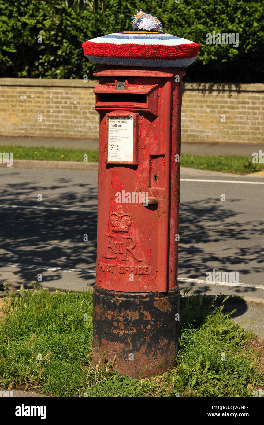 a post box wearing a knitted wooly hat for Christmas seasonal greetings ...