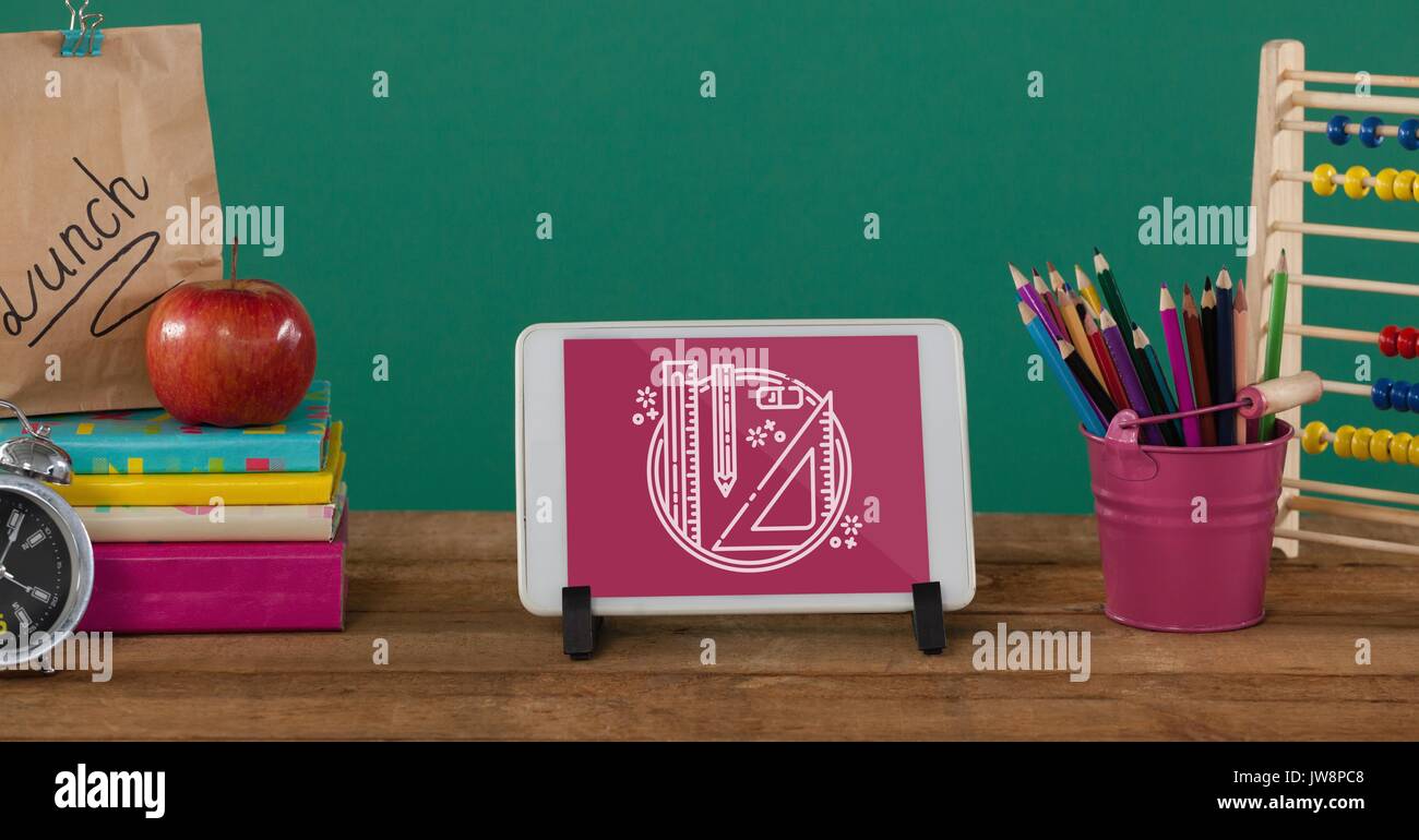 Digital composite of Tablet on a school table with school icons on ...
