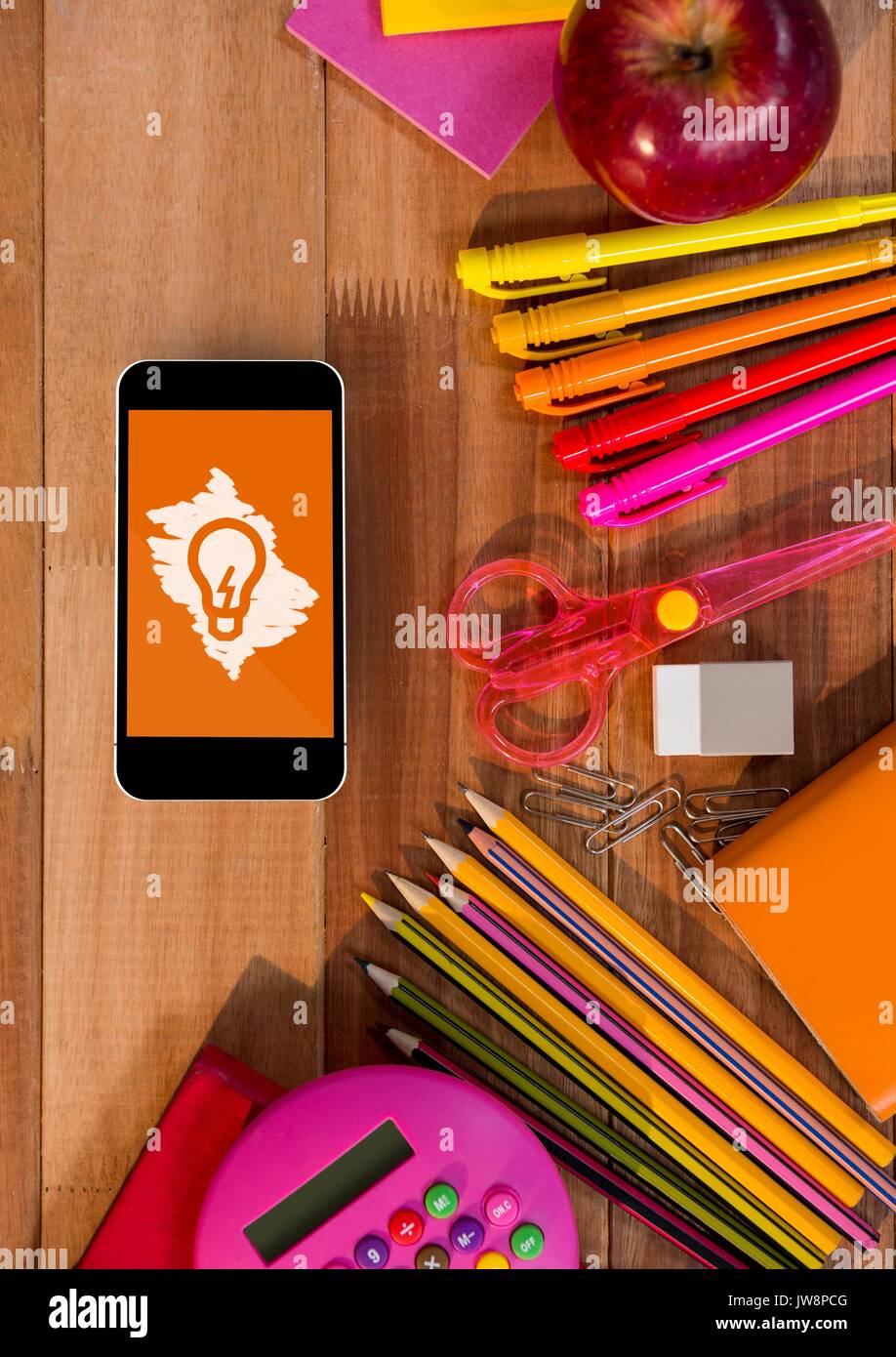 Digital composite of Phone on a school table with bulb icon on screen ...