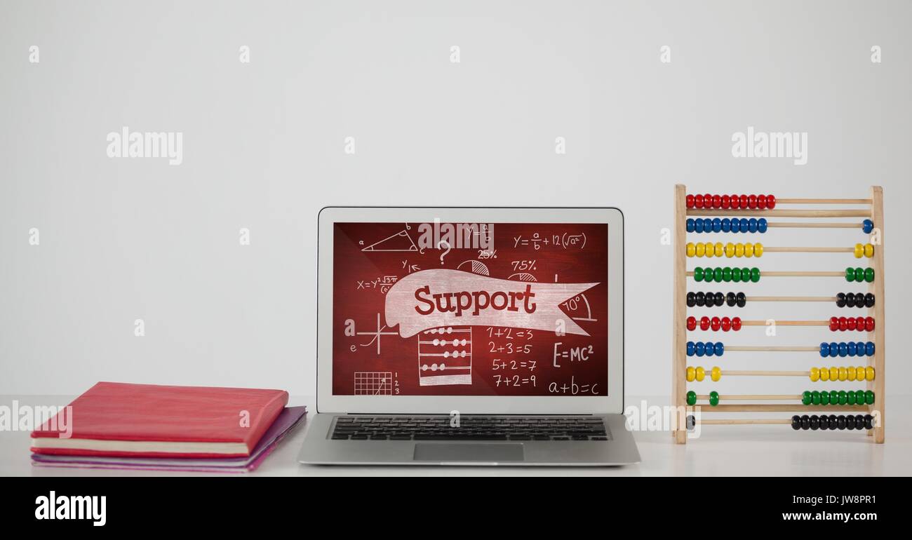 Digital composite of Computer on a school table with school icons on ...