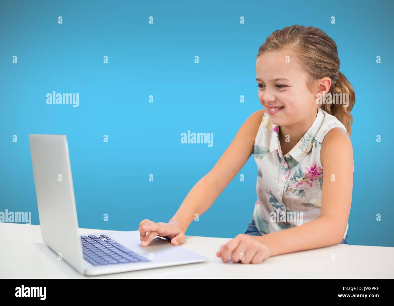 Digital composite of Girl on laptop with blue wall Stock Photo - Alamy