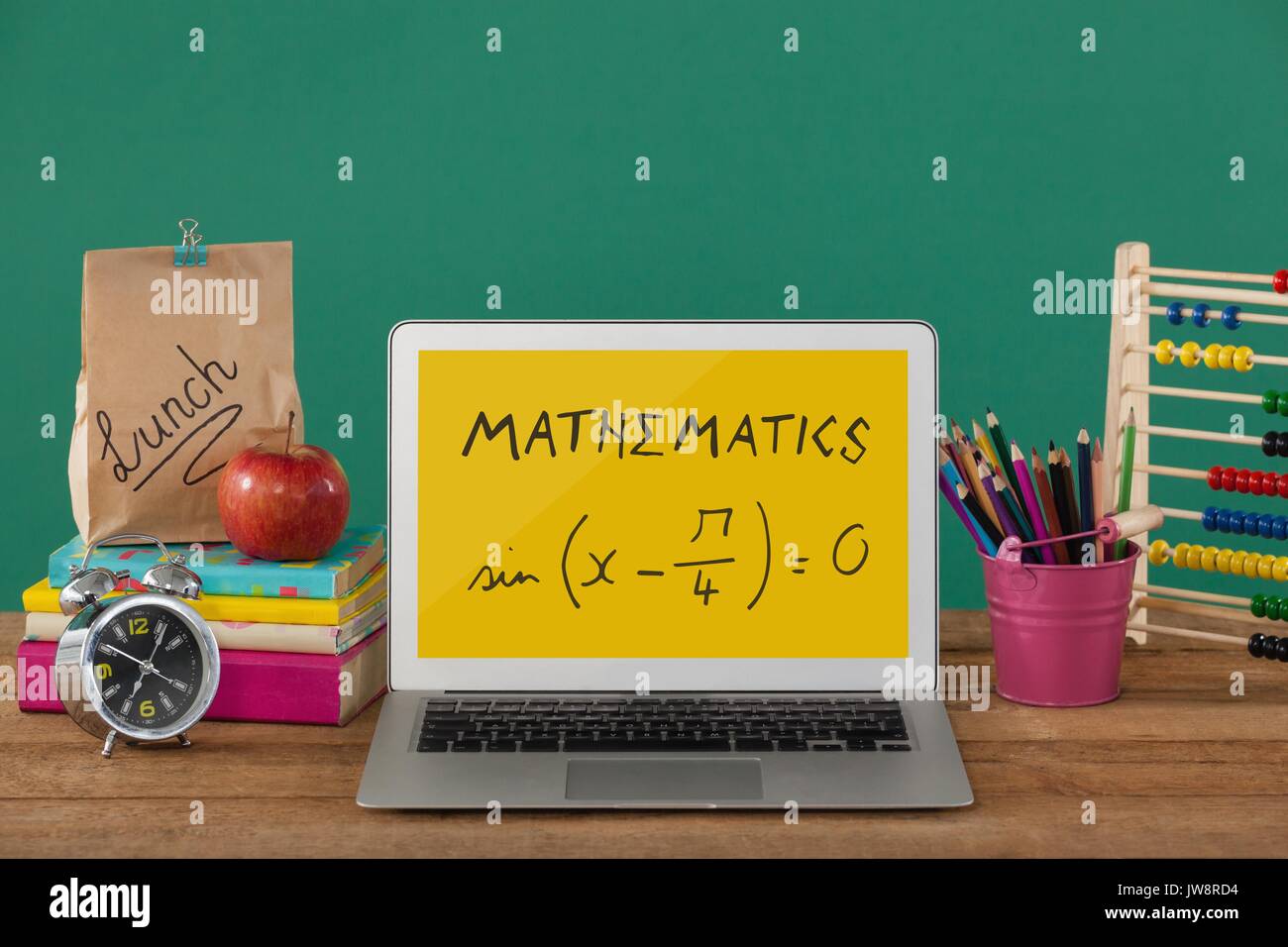 Digital composite of Computer on a school table with school icons on ...