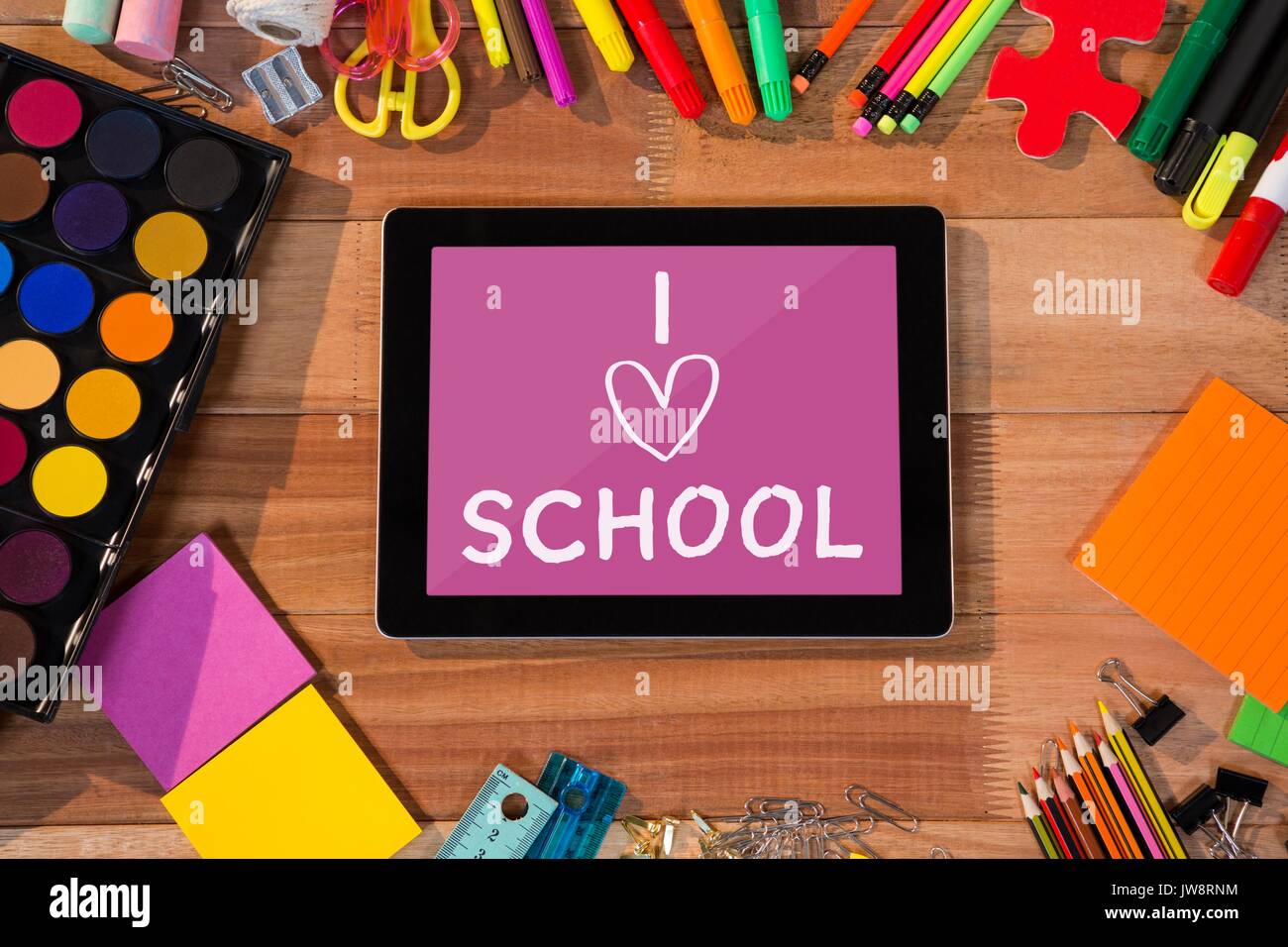 Digital composite of Tablet on a school table with school icons on ...