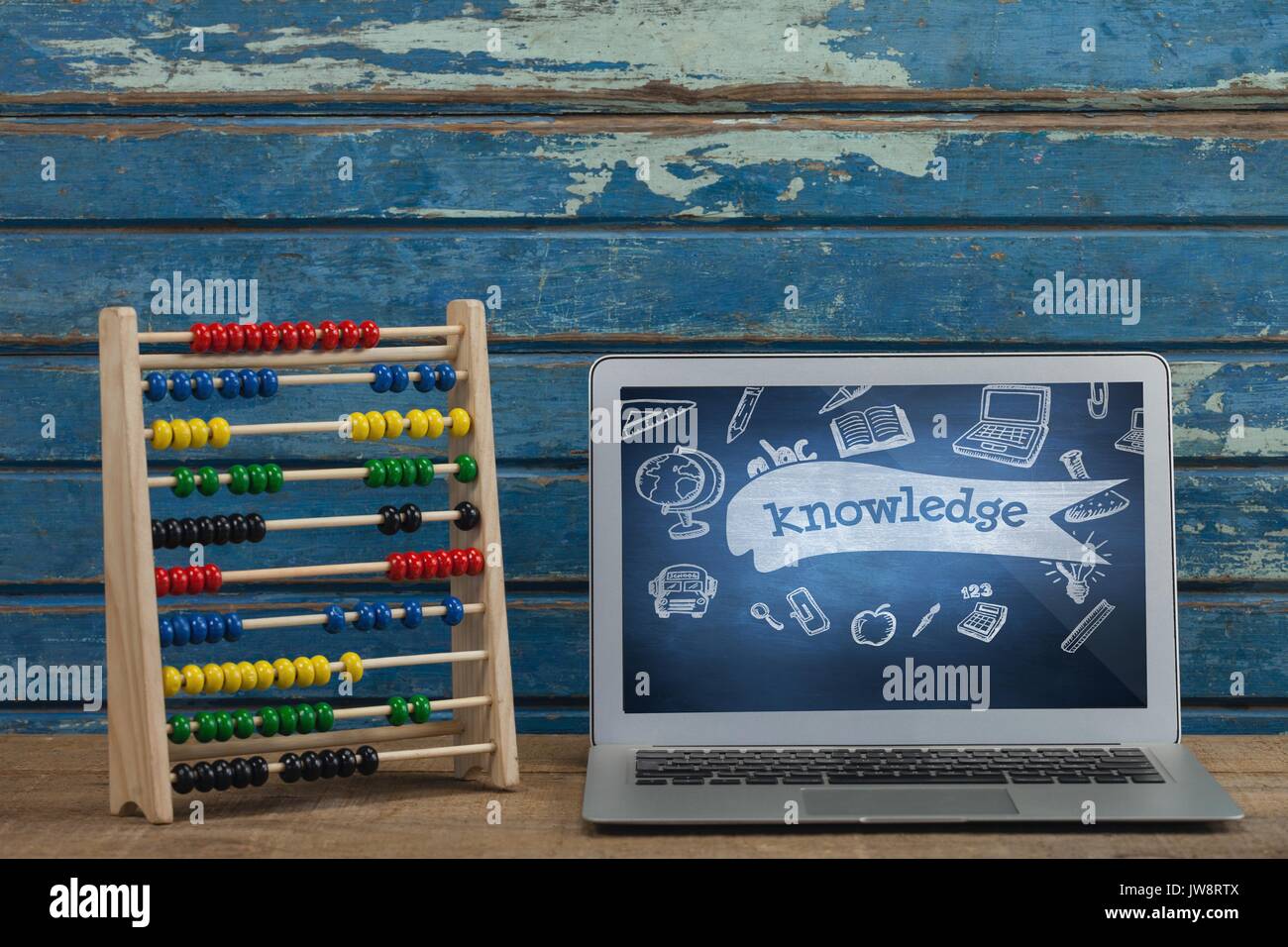 Digital composite of Computer on a school table with school icons on ...