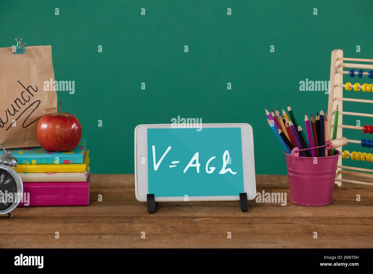 Digital composite of Tablet on a school table with school icons on ...