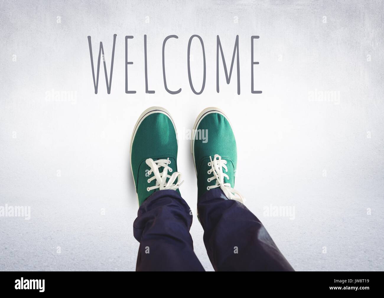 Digital composite of Welcome text and green shoes on feet with grey ...