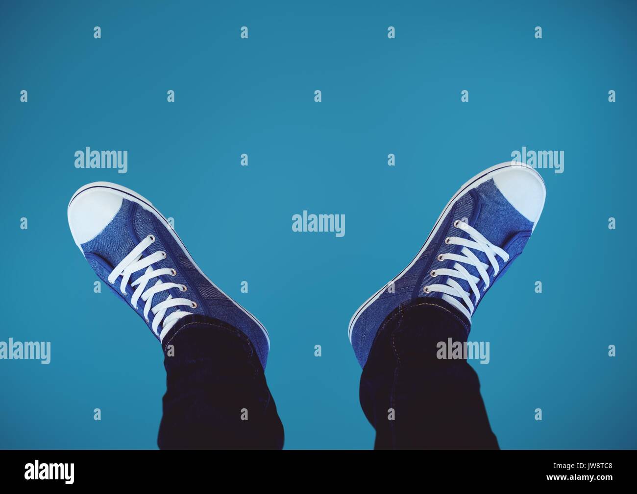 Digital composite of Blue shoes on feet with blue background Stock ...