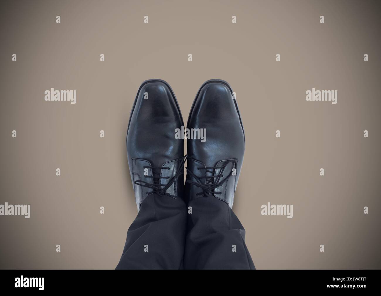 Digital composite of Black shoes on feet with brown background Stock ...