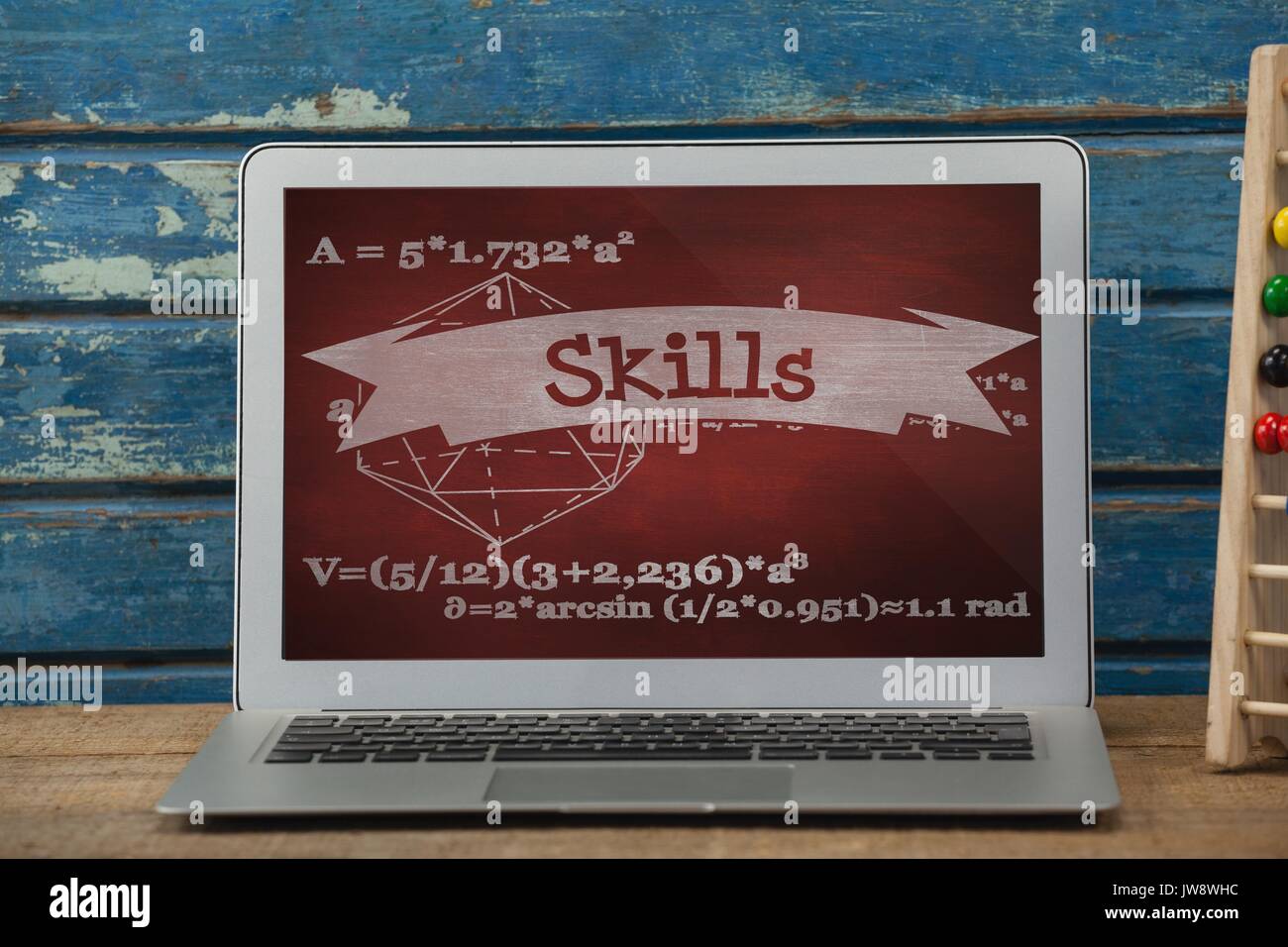 Digital composite of Computer on a school table with school icons on ...