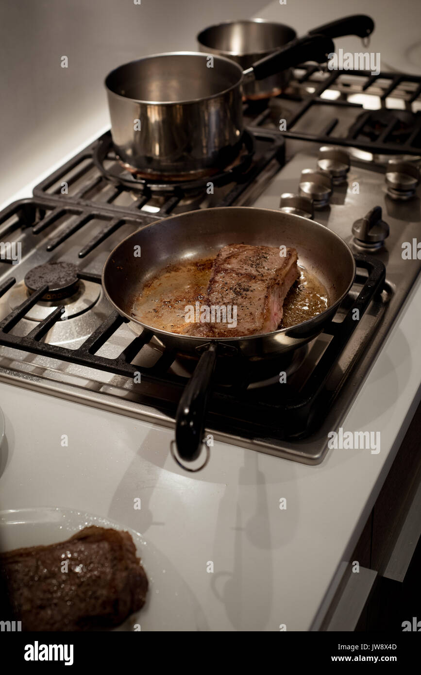 Meat being cooked on a gas stove in kitchen Stock Photo - Alamy