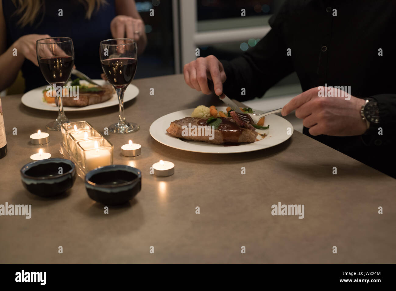 Couple having dinner on dining table in living room at home Stock Photo ...