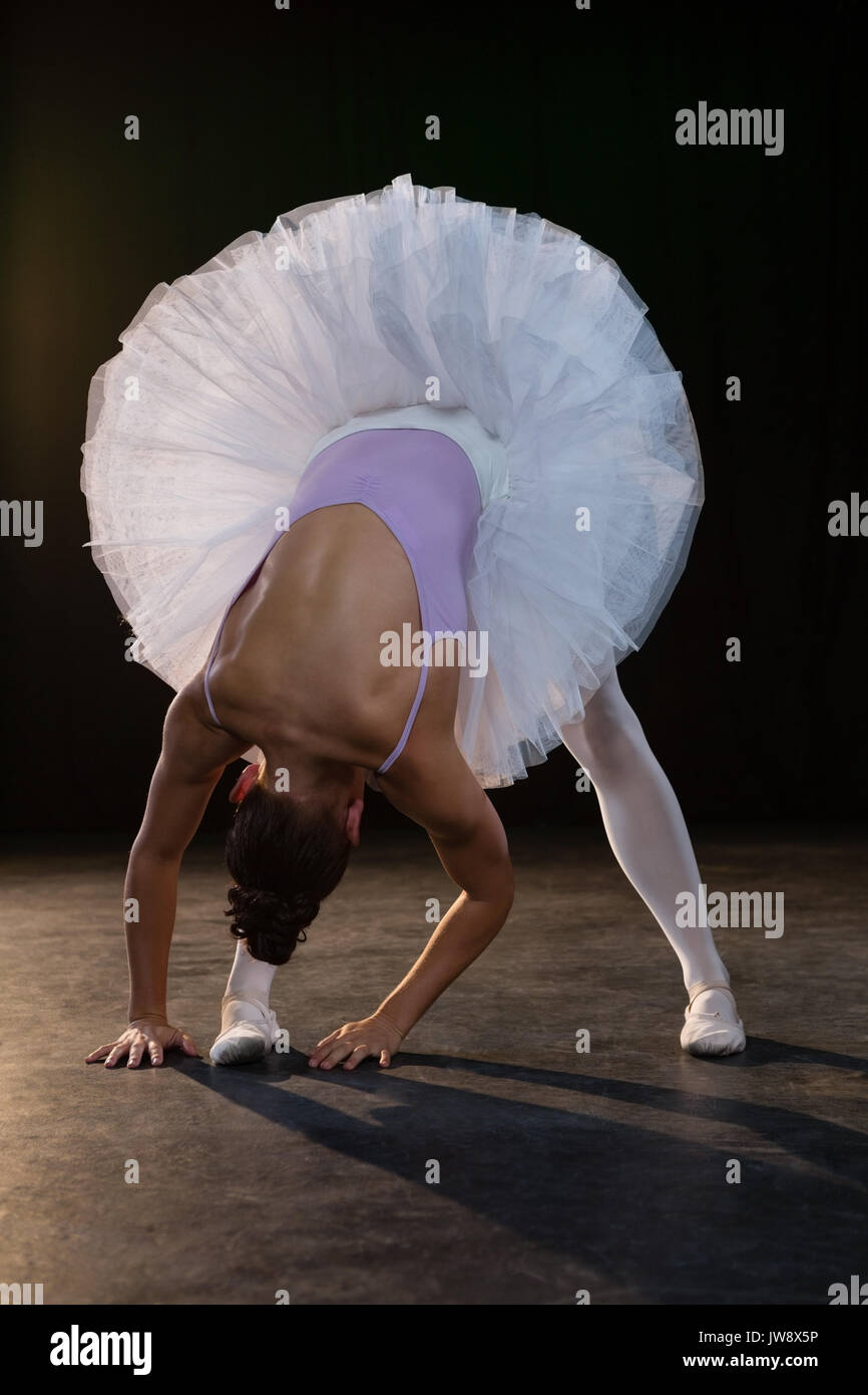 Female ballet dancer stretching before dancing in the studio Stock ...