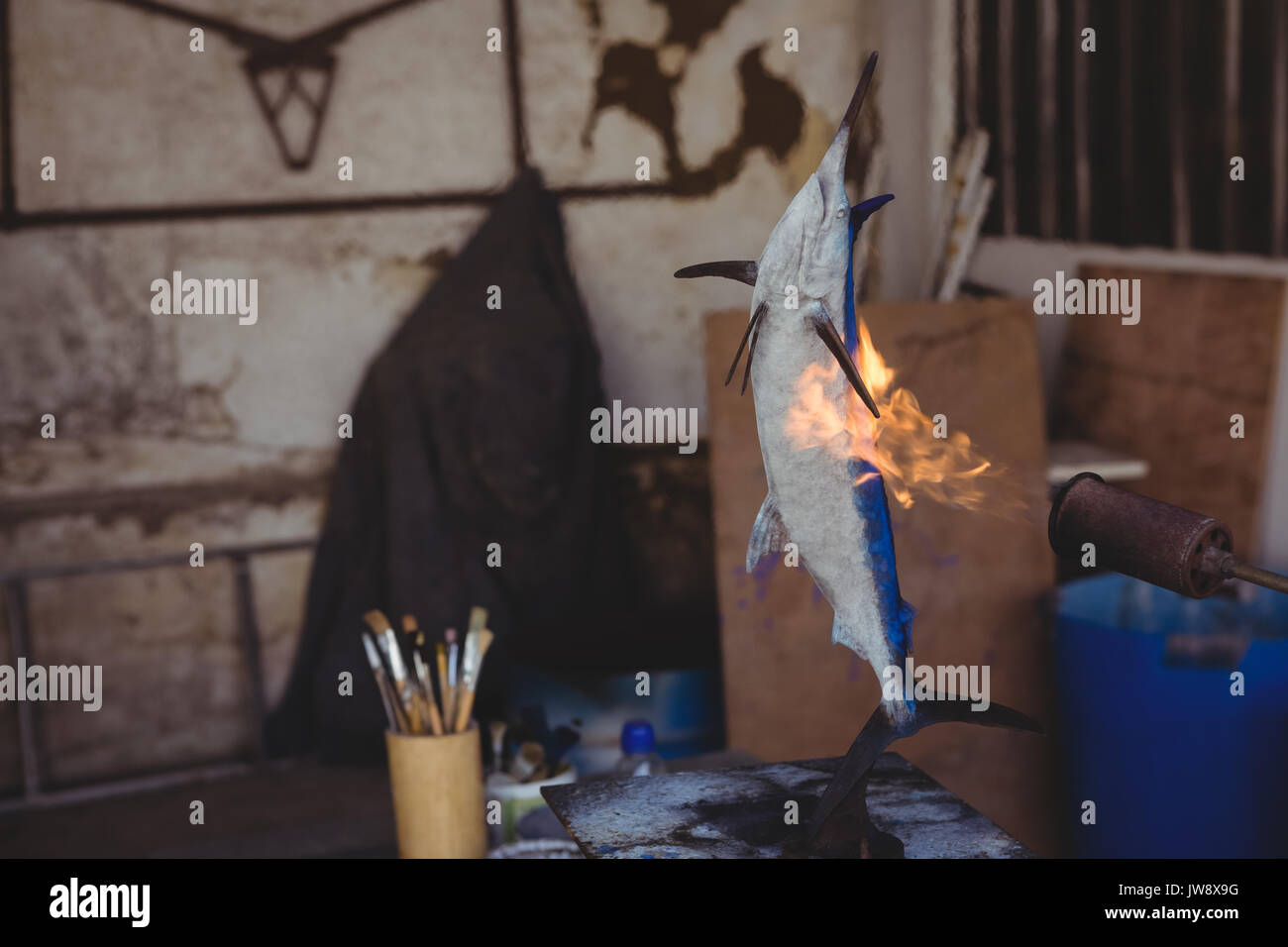 Fish sculpture being heated by burner in workshop Stock Photo - Alamy