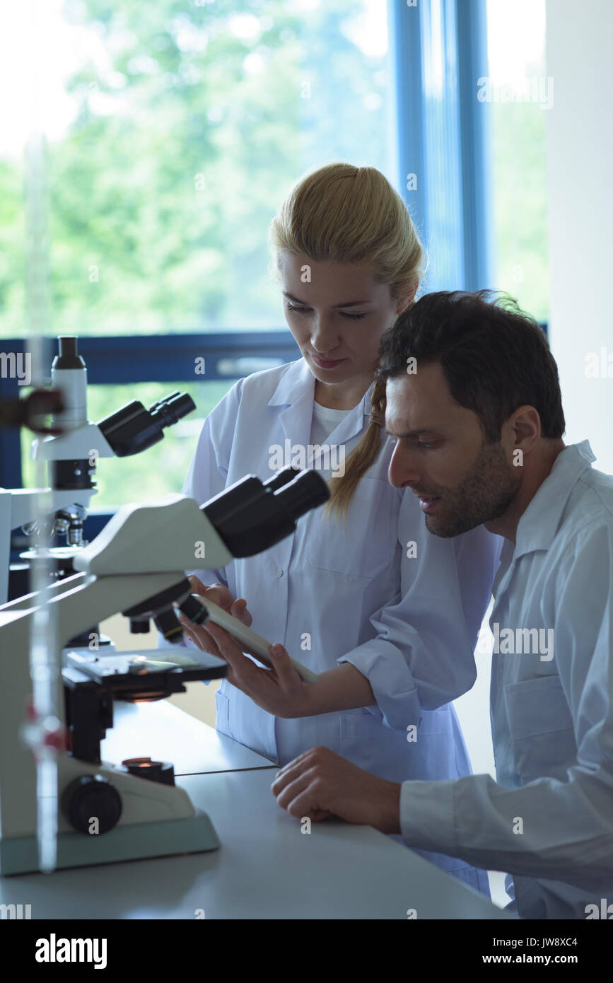 University students using digital tablet while doing experiment on ...