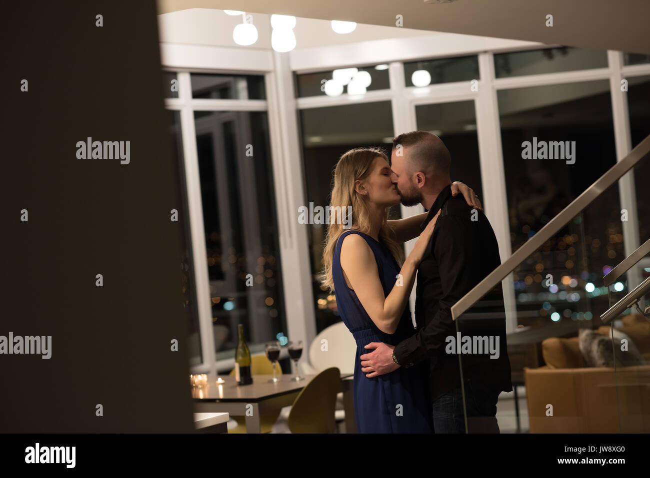 Romantic couple kissing each other in living room at home Stock Photo ...