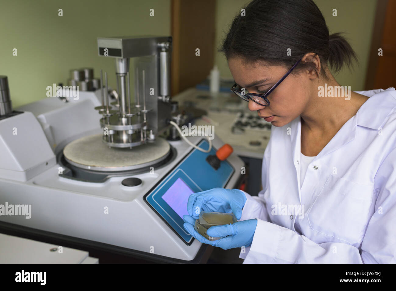 Teenage female student using machinery in laboratory at college Stock ...